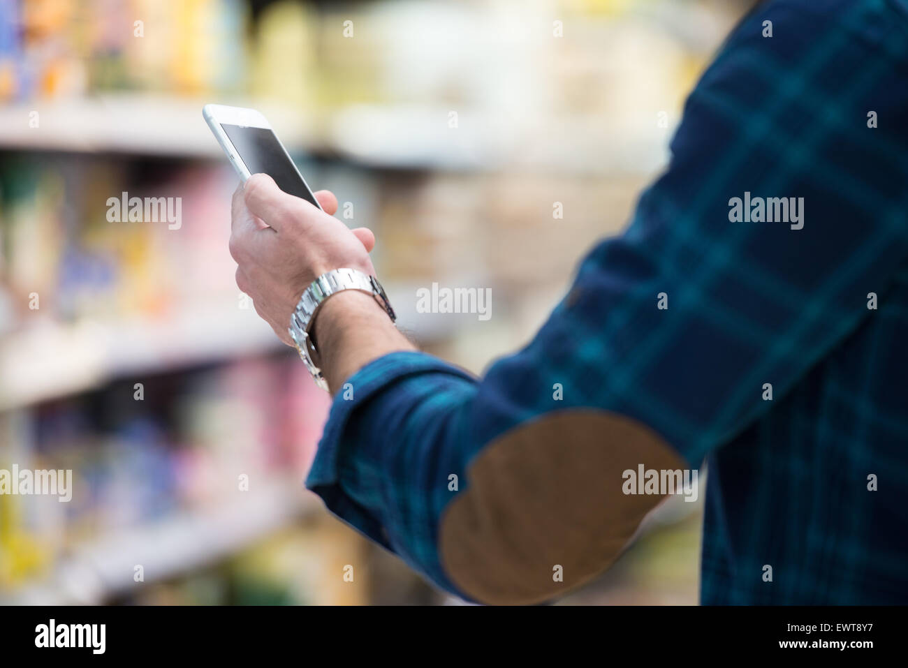 Smiling Young Man Using Mobile Phone While Shopping In Shopping Store ...