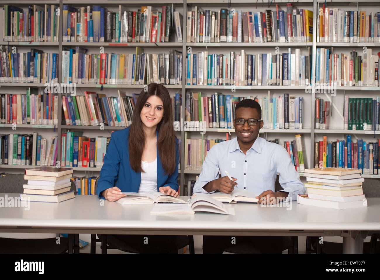 Portrait Of Clever Students With Open Book Reading It In College ...