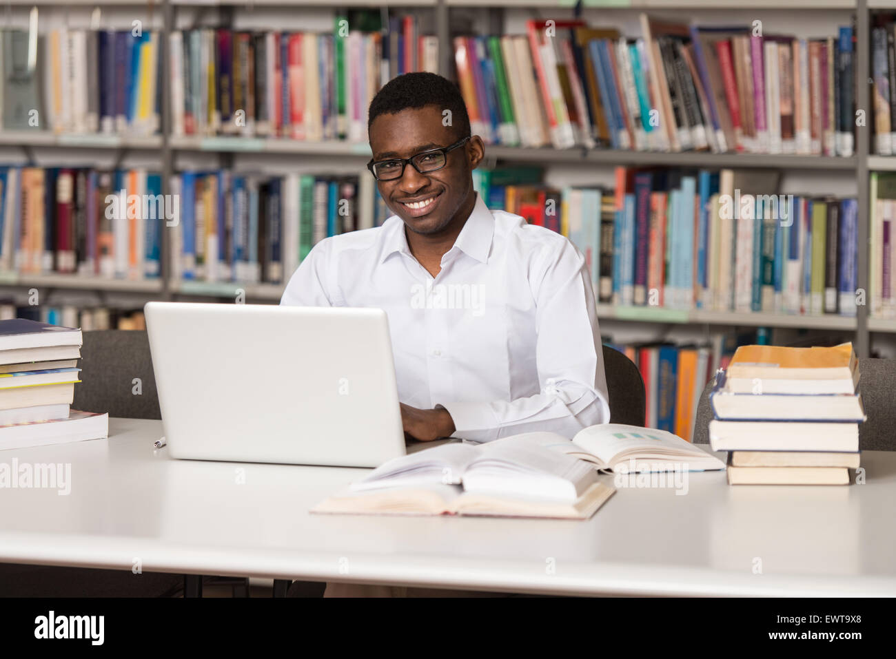 In The Library - Handsome African Male Student With Laptop And Books ...