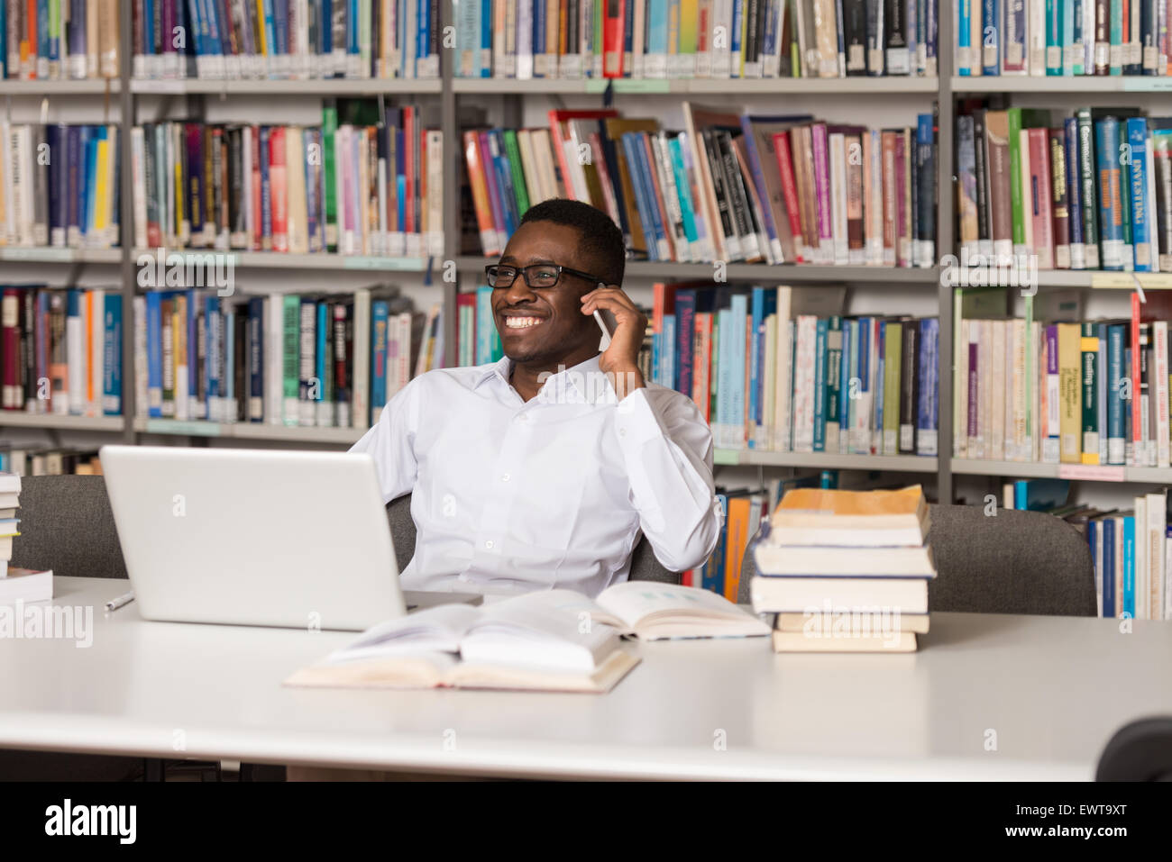 African Male Student Talking On The Phone In Library - Shallow Depth Of ...
