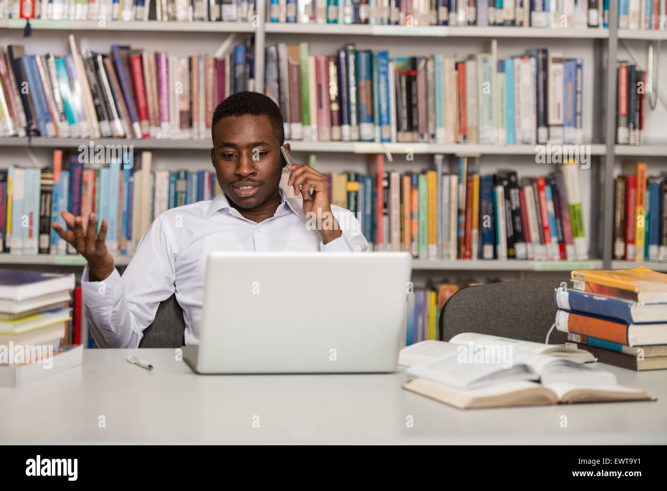 African Male Student Talking On The Phone In Library - Shallow Depth Of ...