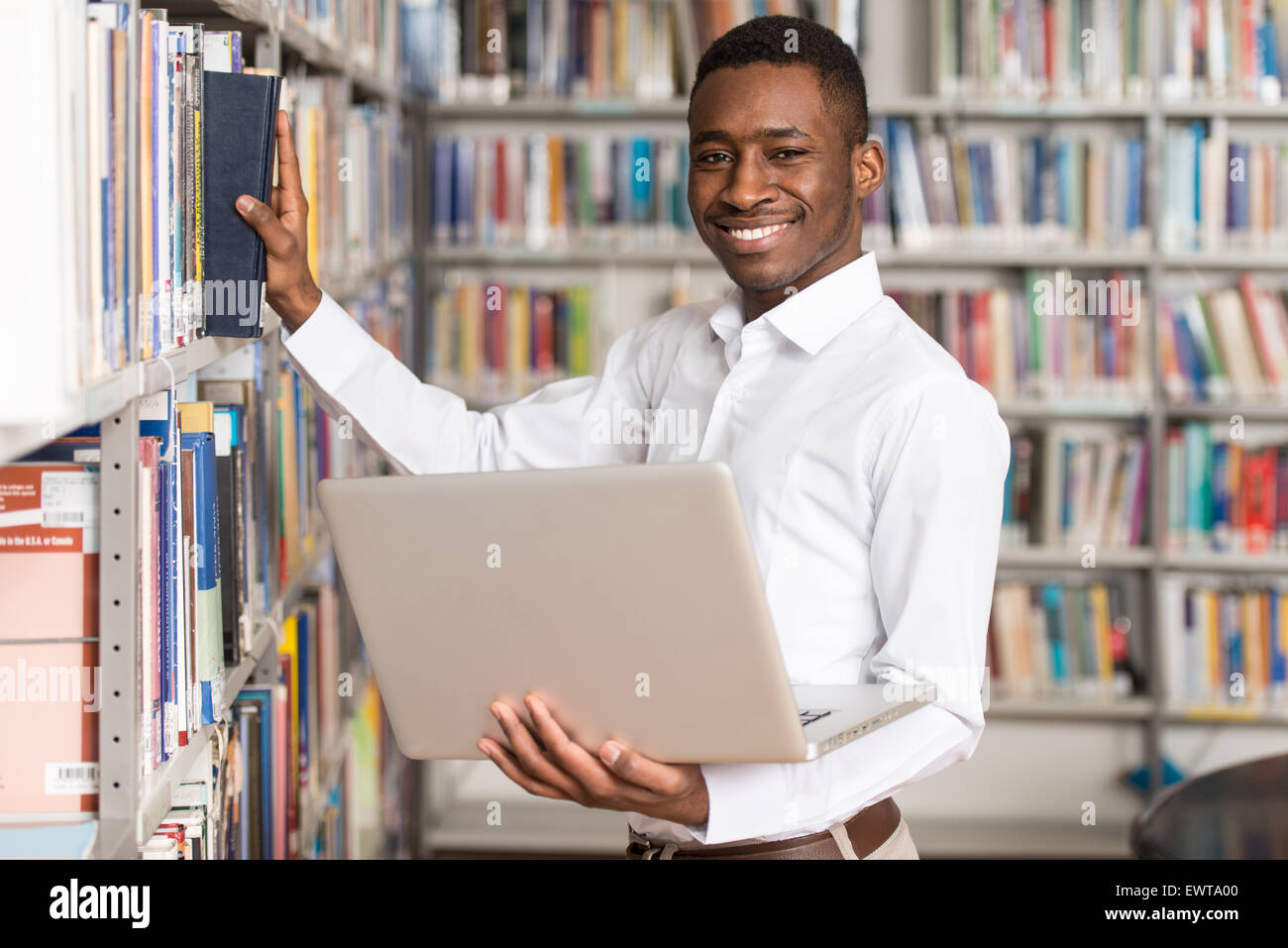 In The Library - Handsome Male Student With Laptop And Books Working In ...