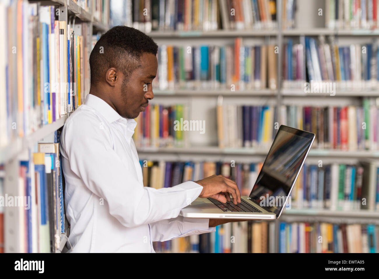 In The Library - Handsome Male Student With Laptop And Books Working In ...