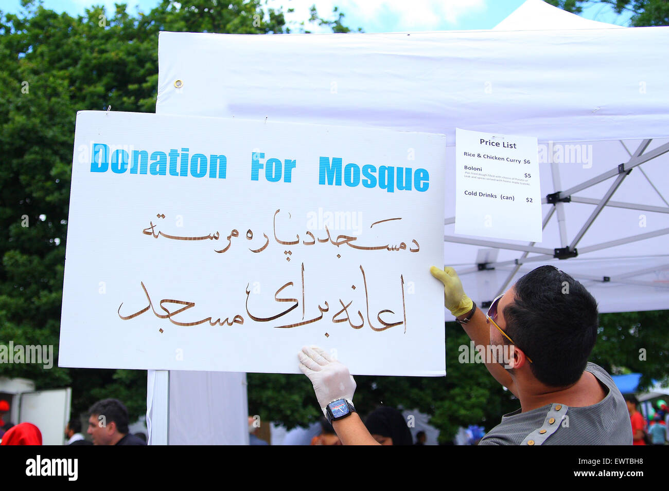 A muslim man hanging a sign for Donation for mosque at one of the ...