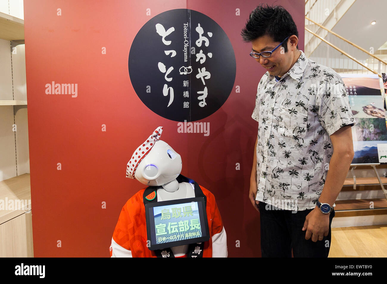 Tokyo, Japan. 1st July, 2015. A customer greets to the humanoid robot ...