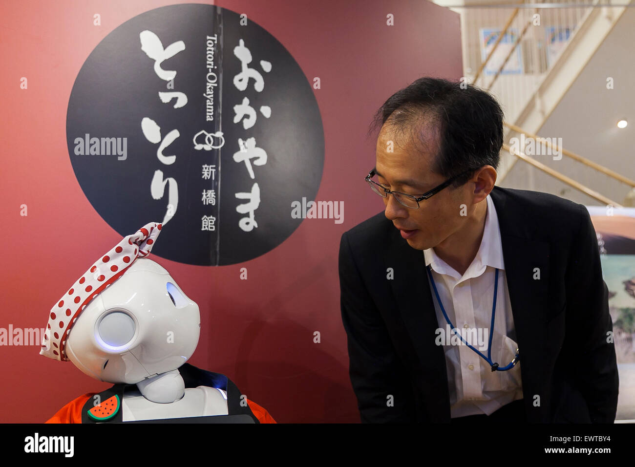 Tokyo, Japan. 1st July, 2015. A customer greets to the humanoid robot ...