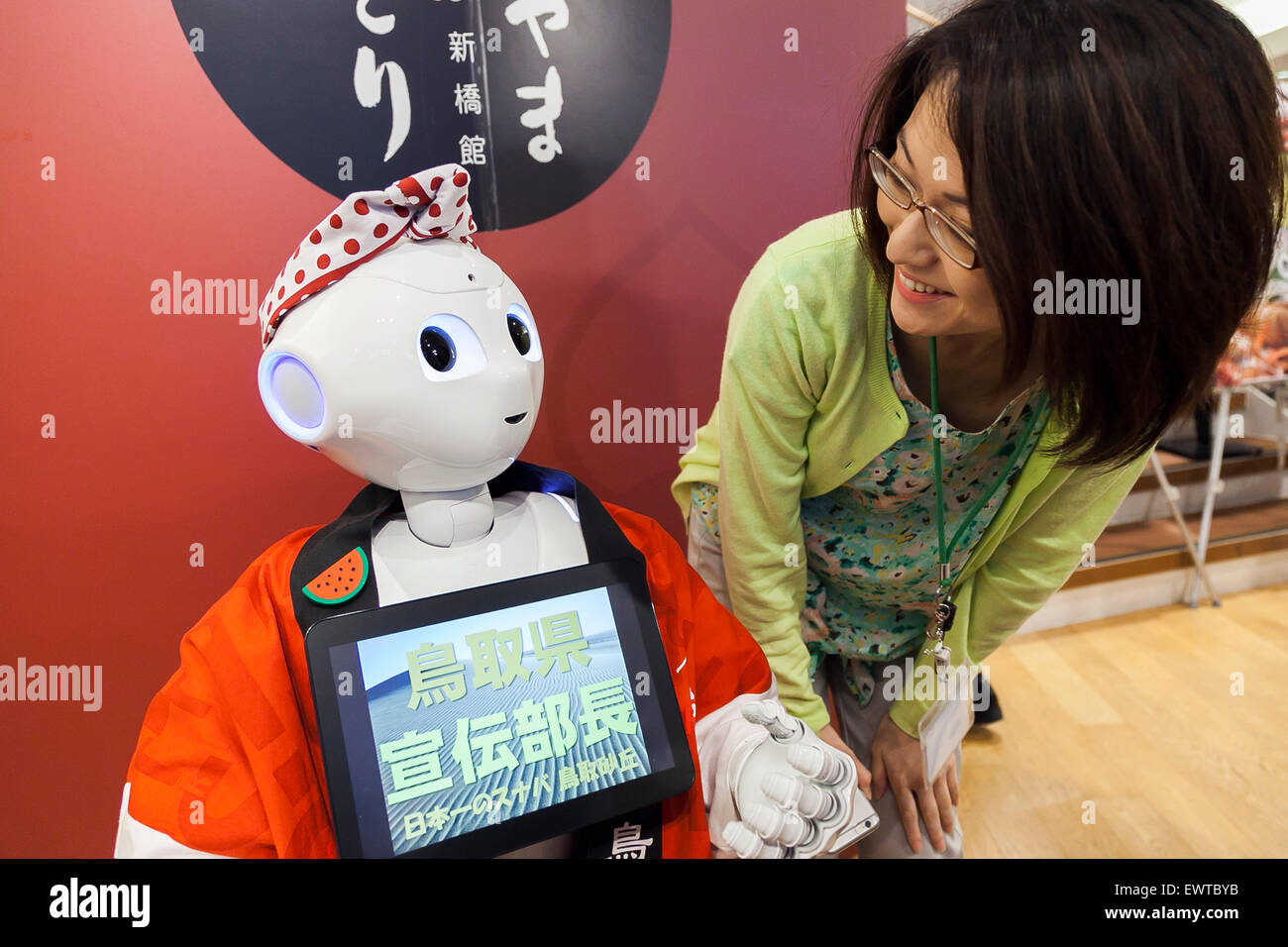 Tokyo, Japan. 1st July, 2015. A customer greets to the humanoid robot ...