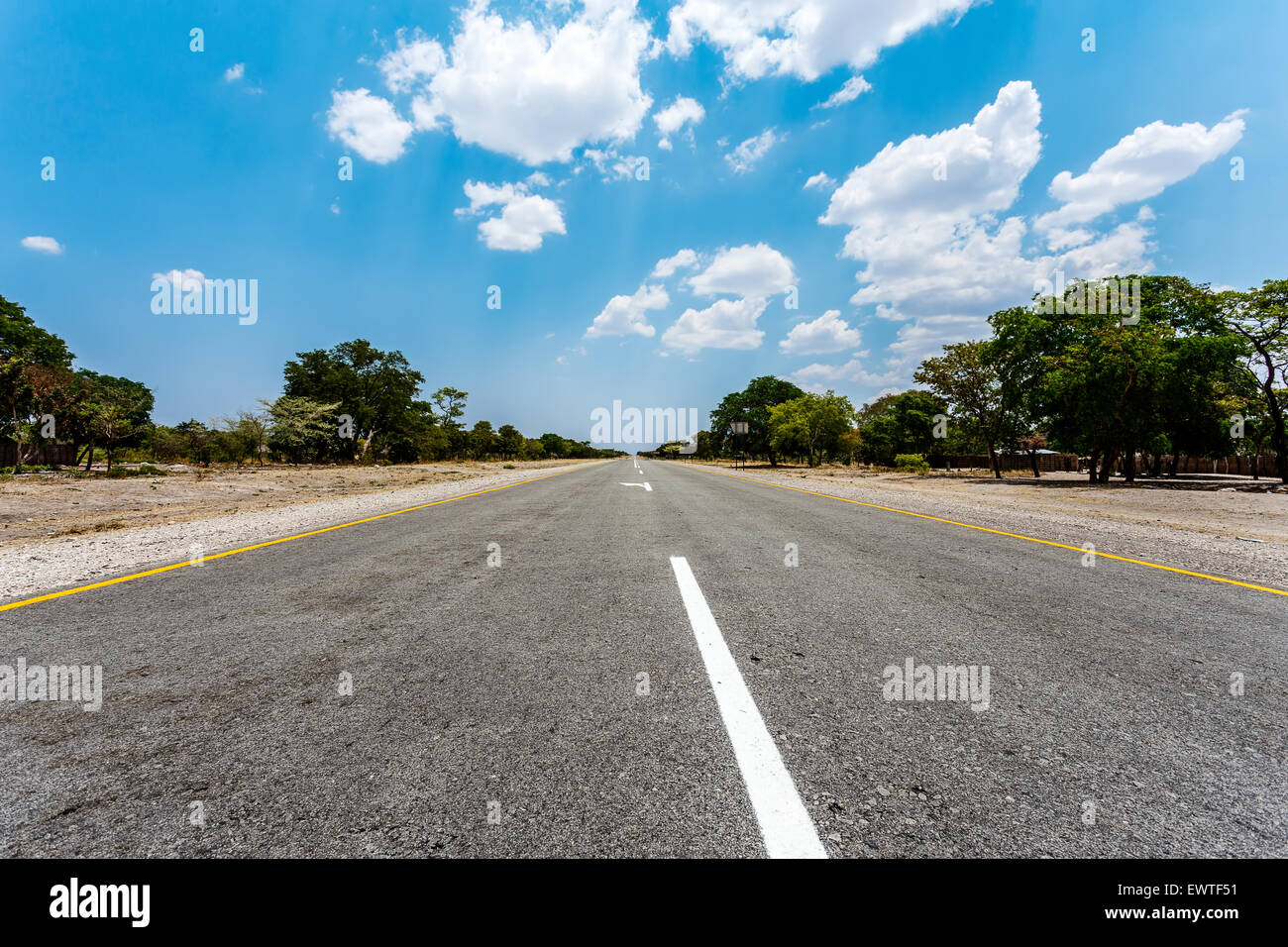 Endless road in Namibia, Caprivi Game Park, with blue sky Stock Photo ...