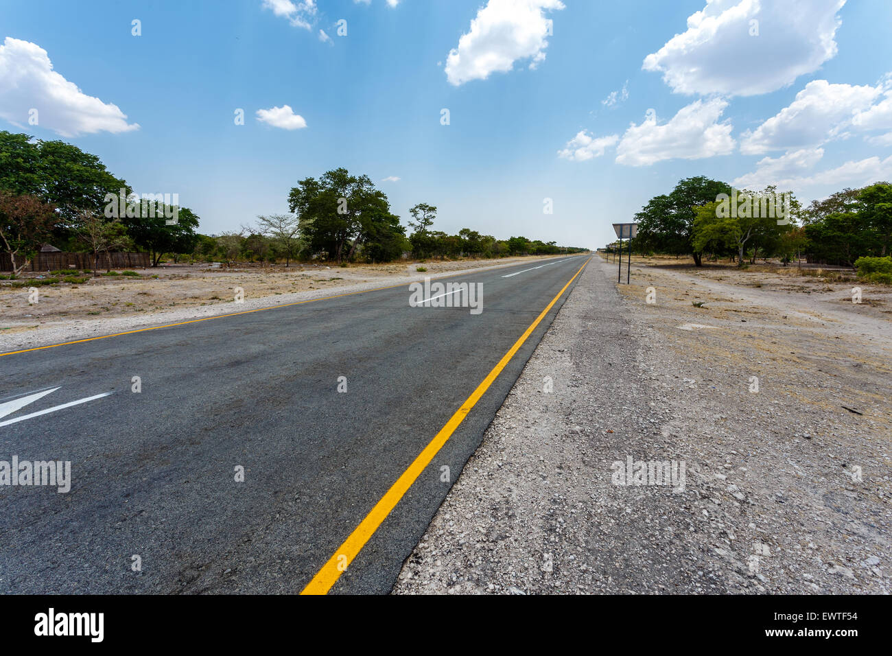 Endless road in Namibia, Caprivi Game Park, with blue sky Stock Photo ...