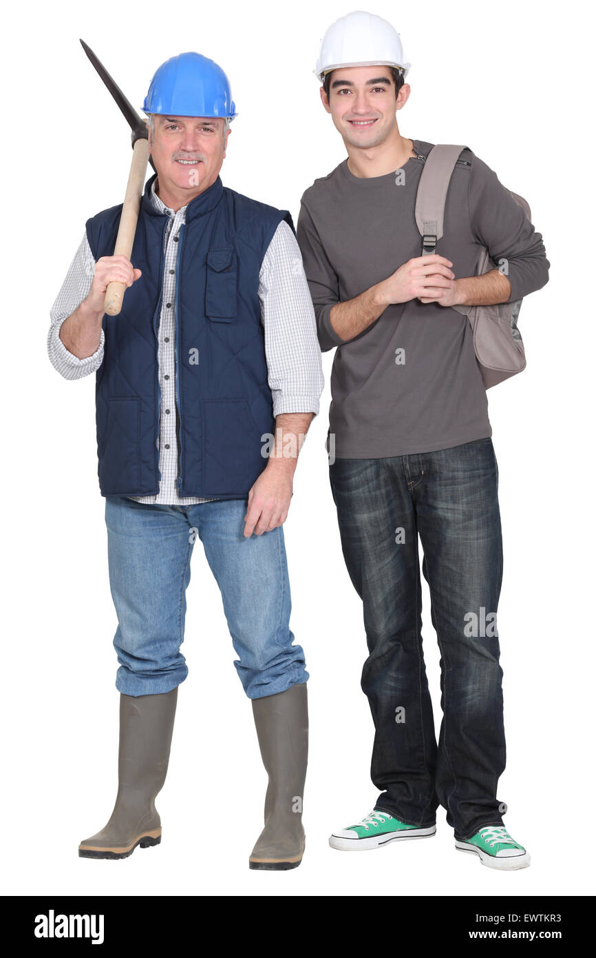 Tradesman standing next to apprentice Stock Photo - Alamy