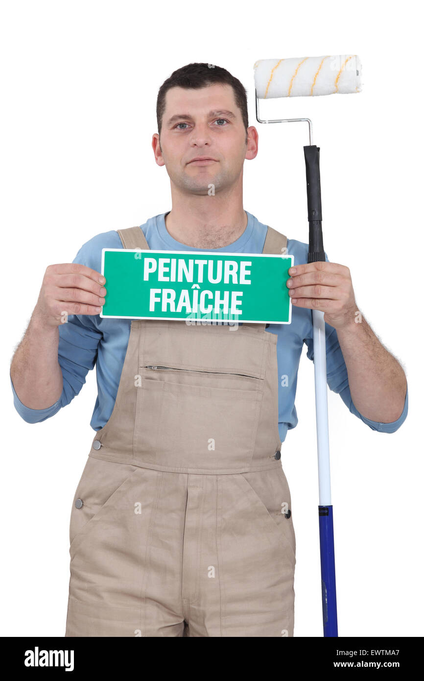 painter holding fresh paint sign and roller Stock Photo - Alamy