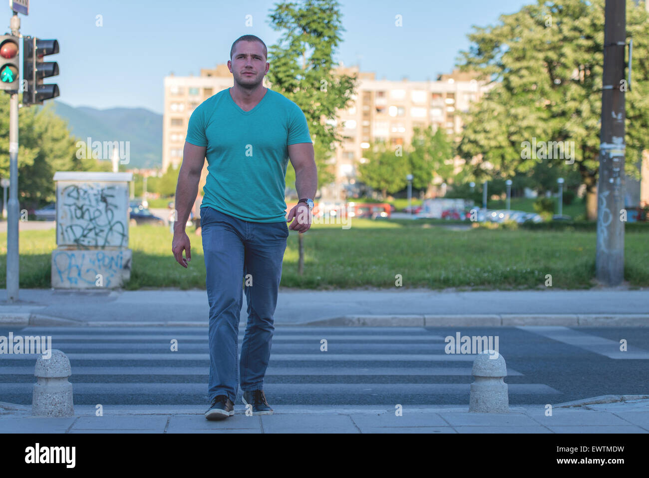 young man walking on zebra crossing Stock Photo - Alamy