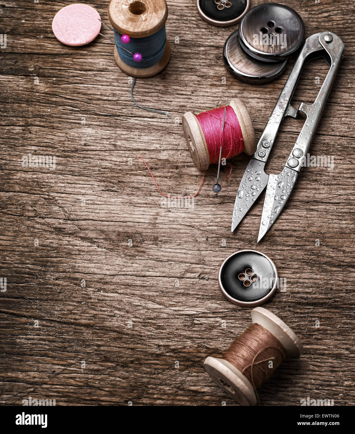 Scissors,thread and buttons on old wooden background.Photo tinted Stock ...
