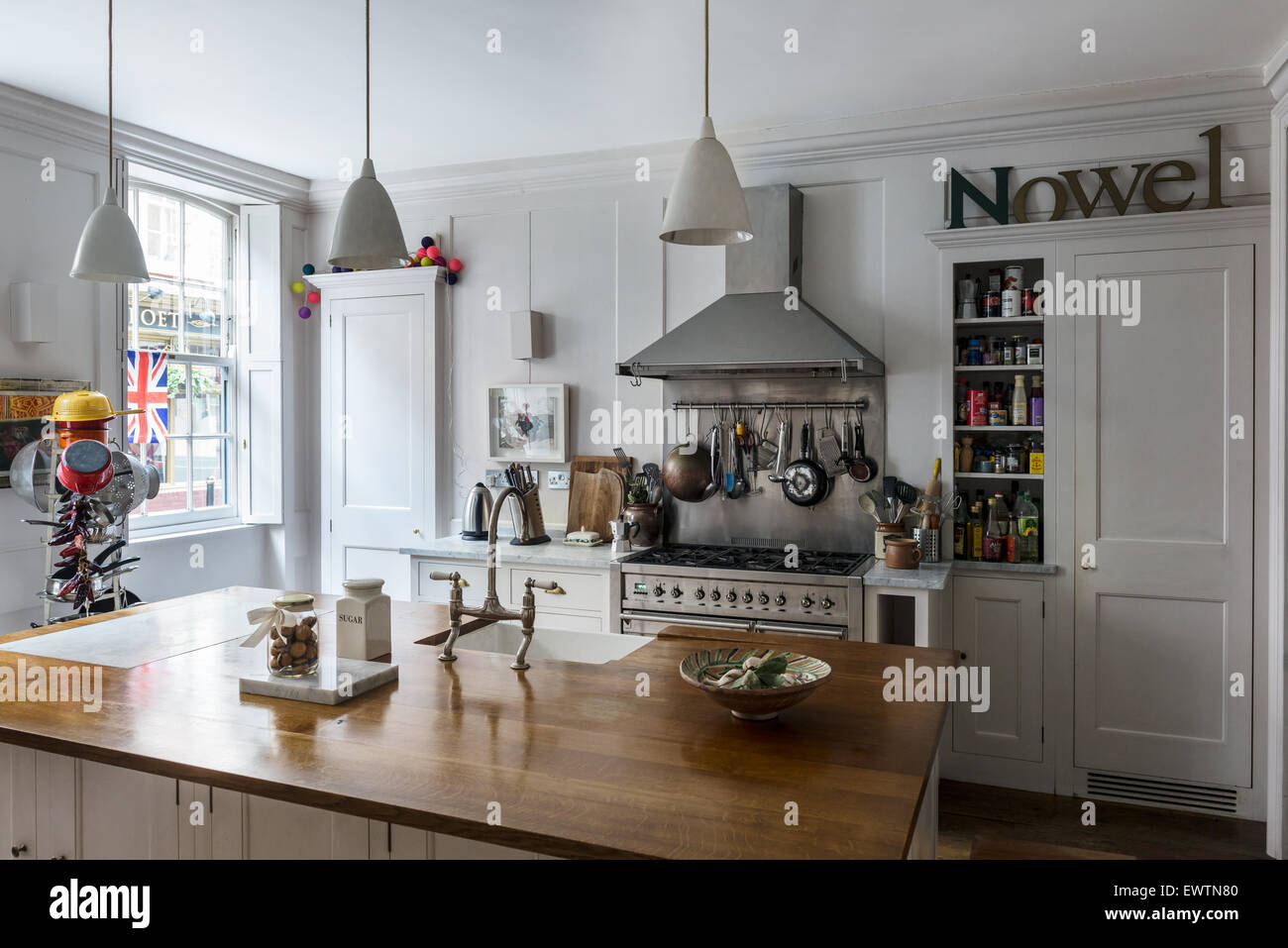 Spacious and light filled kitchen with wood-topped island unit, pendant ...