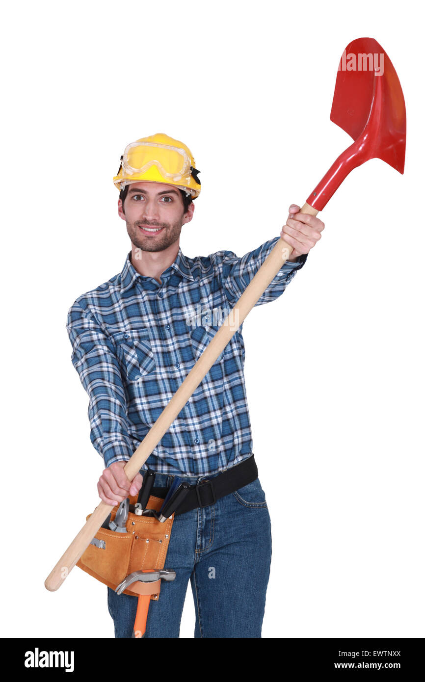 Builder handing over shovel Stock Photo - Alamy
