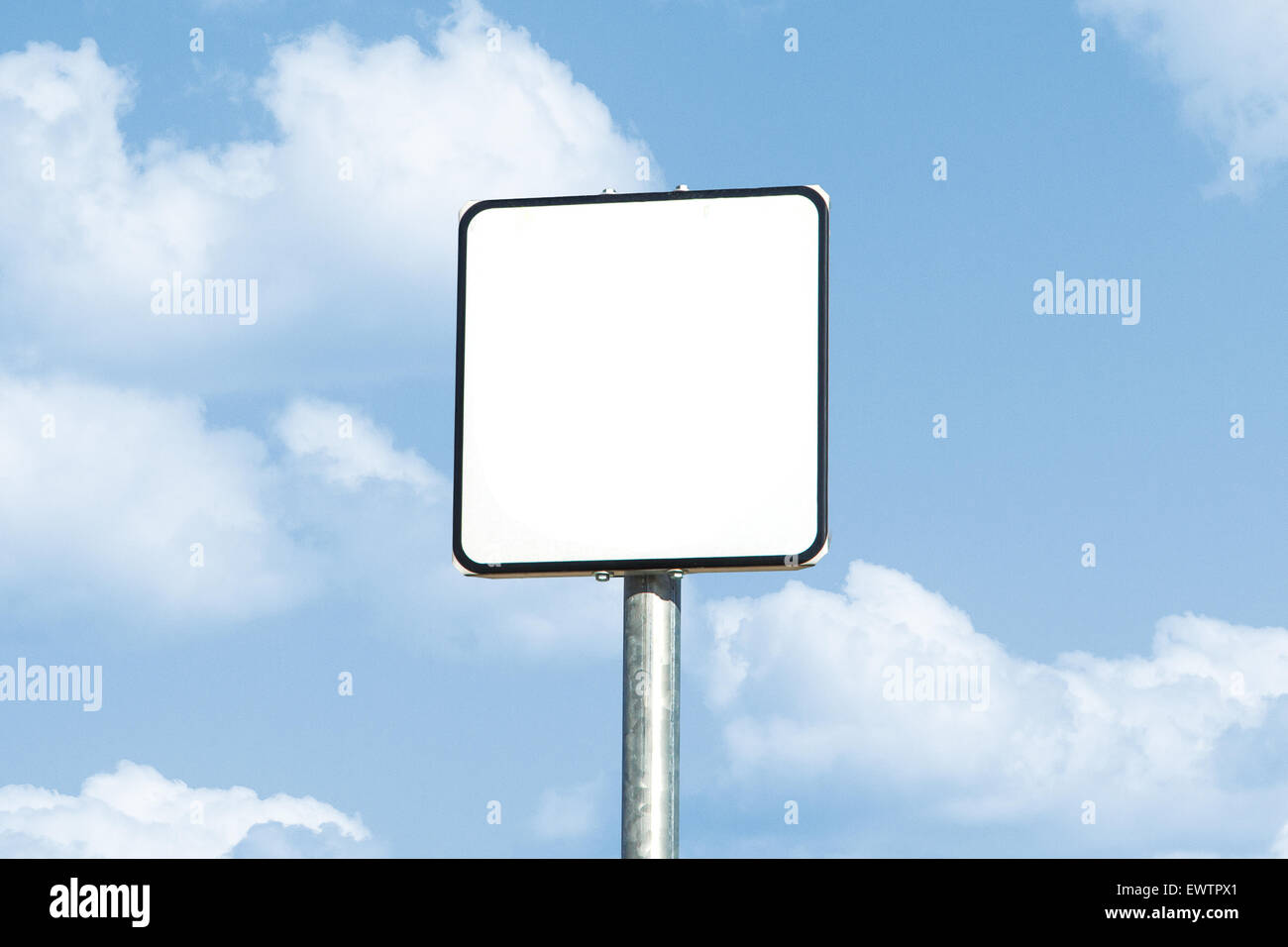 Front view of white empty signboard, on cloudy blue sky background ...