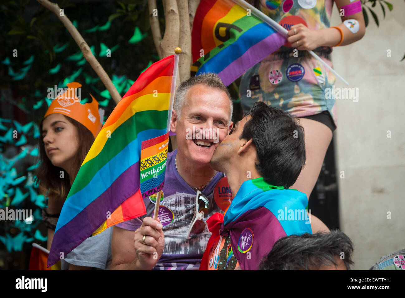 two men holding rainbow flags kissing at Pride in London 2015 Stock ...