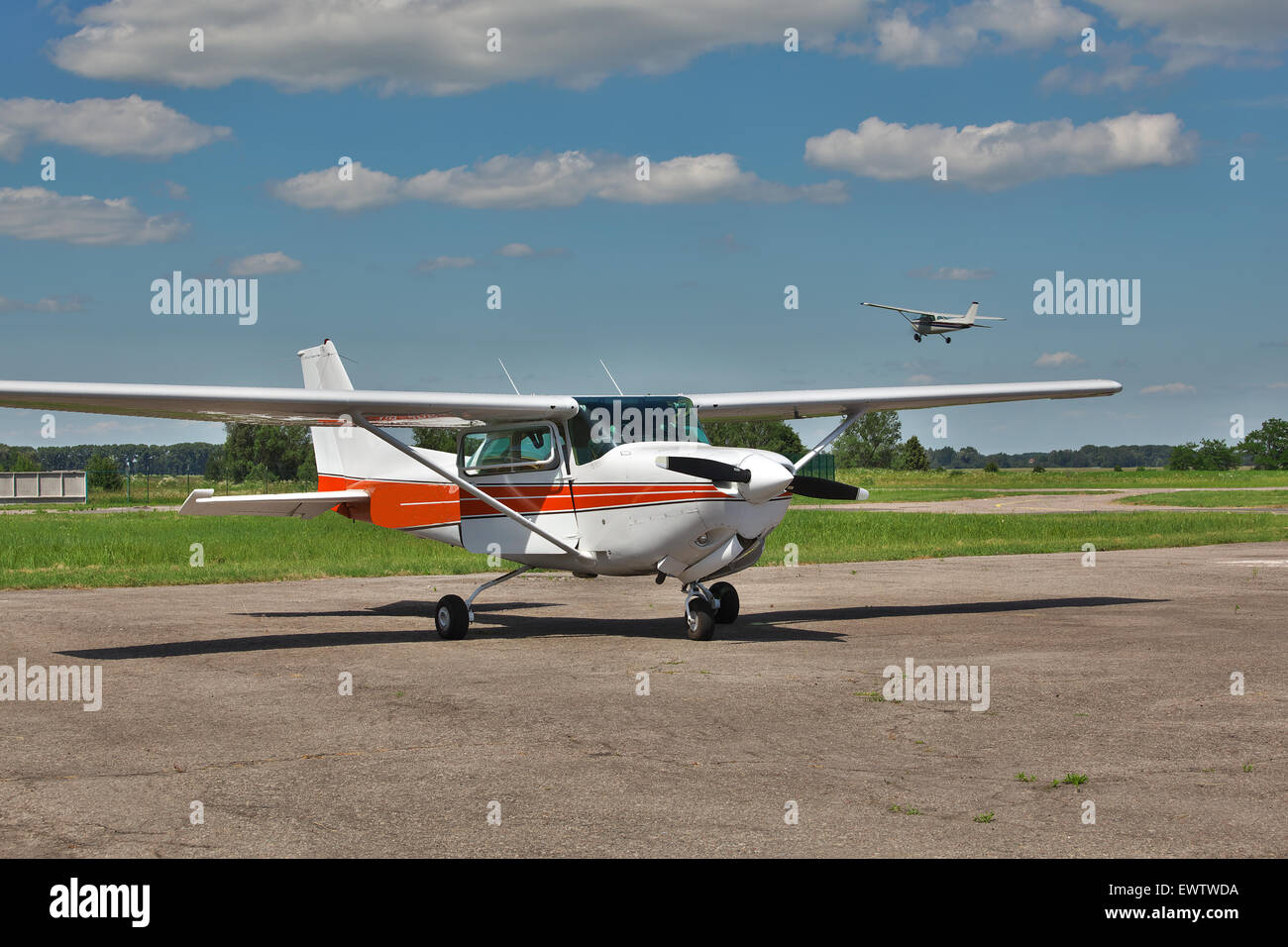 Light plane parked on the private airfield while another one is taking ...