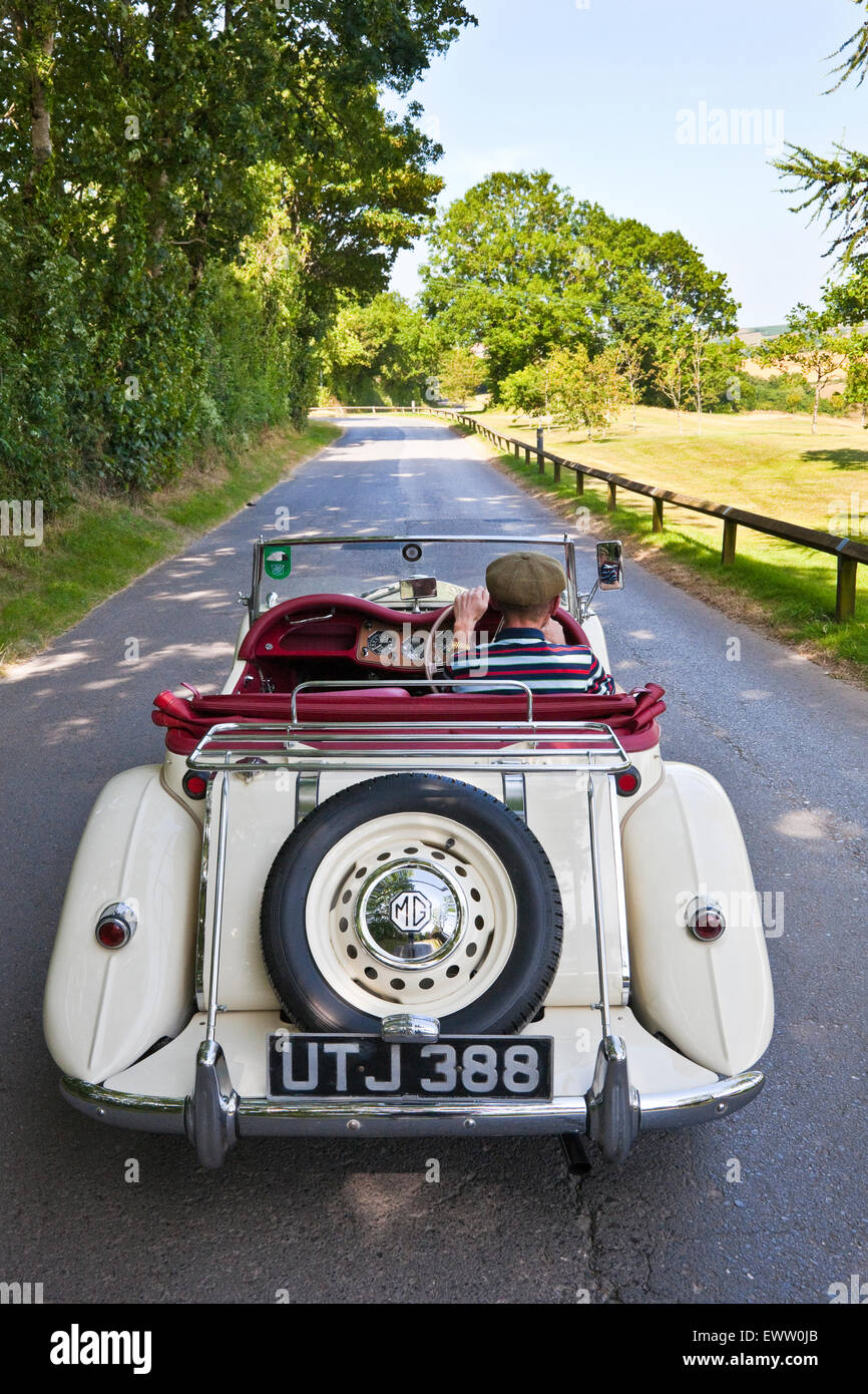 Rear view of white MG TF 1500 classic car being driven down a country ...