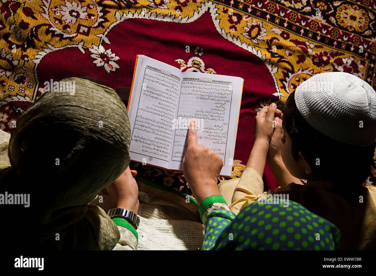 indian Muslim mother and kids reading Quran book Stock Photo - Alamy