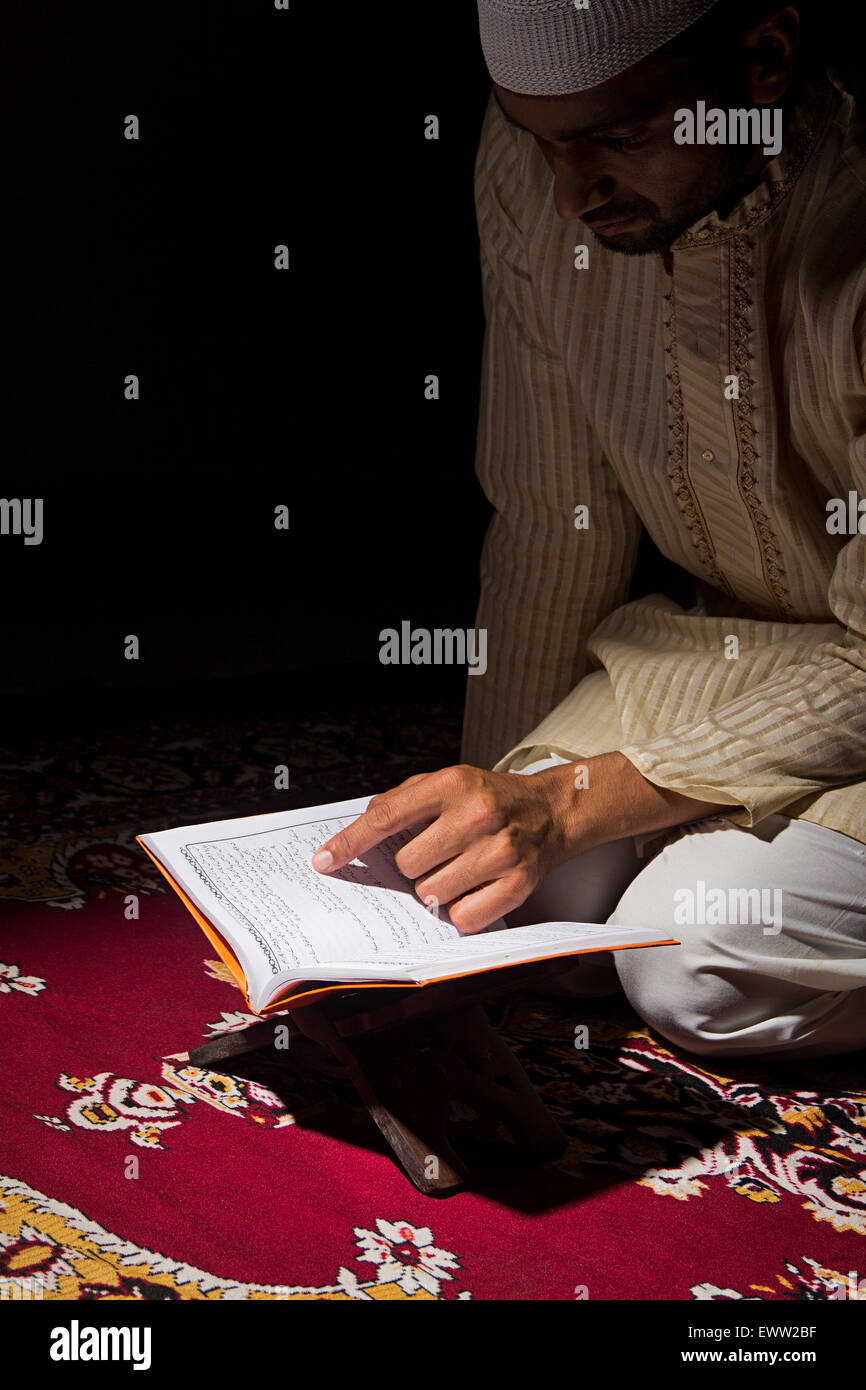 1 indian Muslim man reading Quran book Stock Photo - Alamy