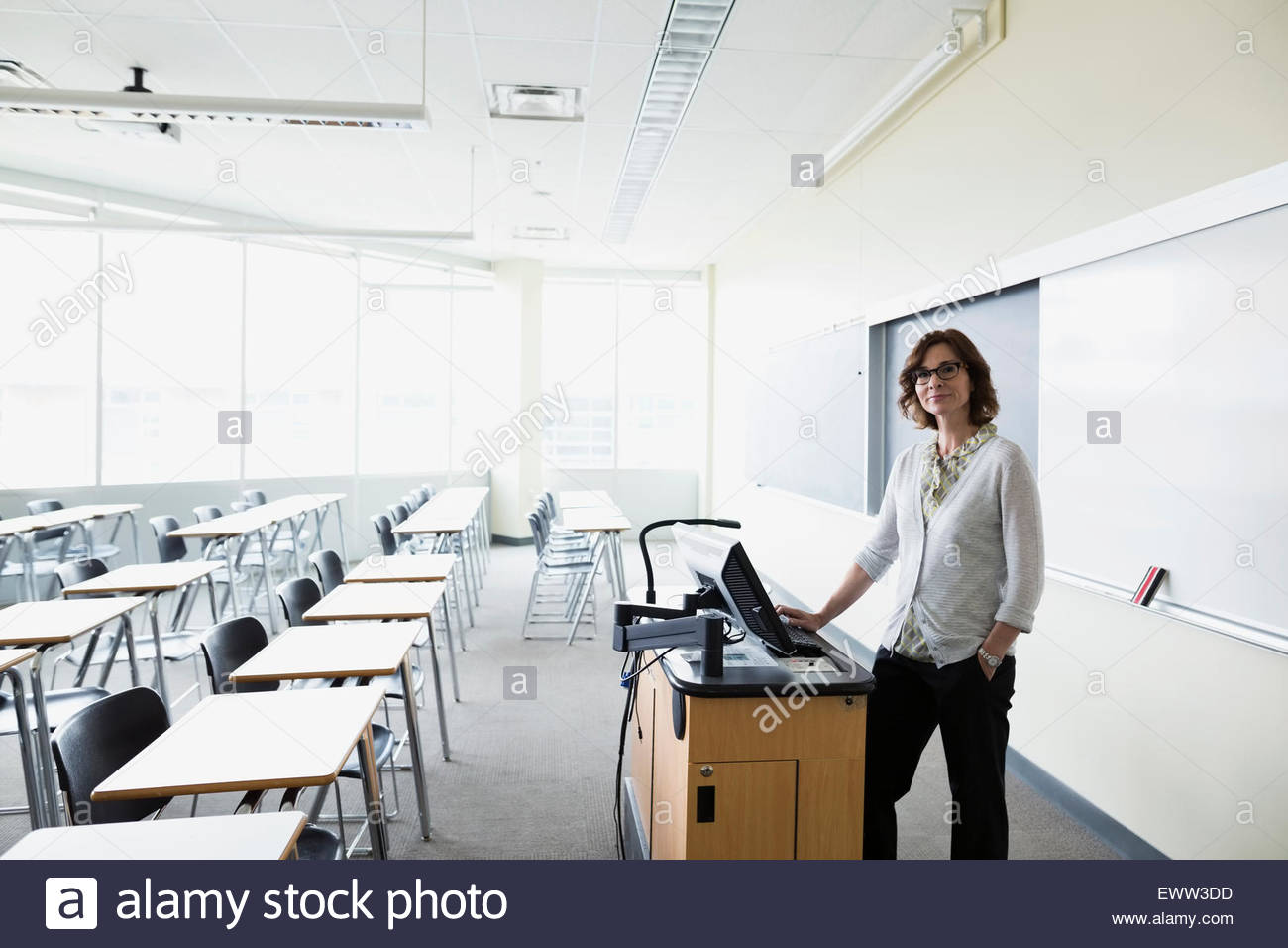 Portrait smiling professor preparing at computer in classroom Stock ...