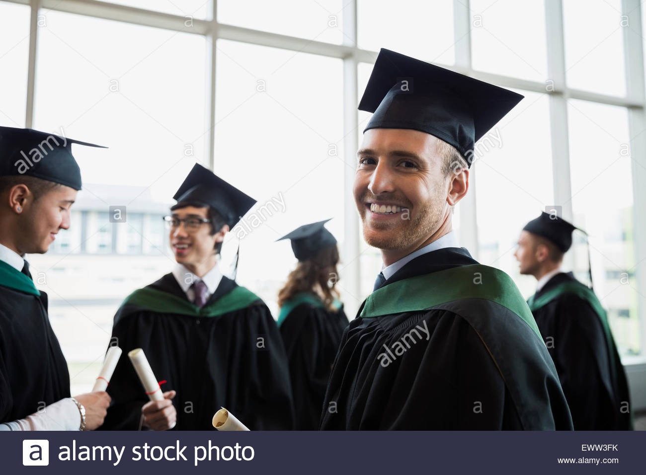 Portrait of young man in graduating cap and gown hi-res stock ...