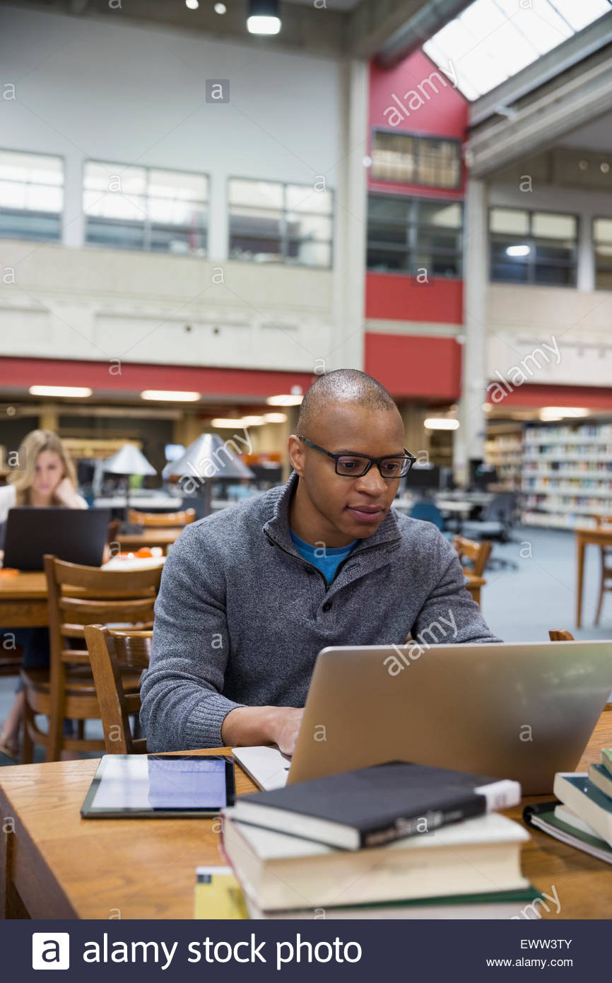 Studying in library laptop book hi-res stock photography and images - Alamy