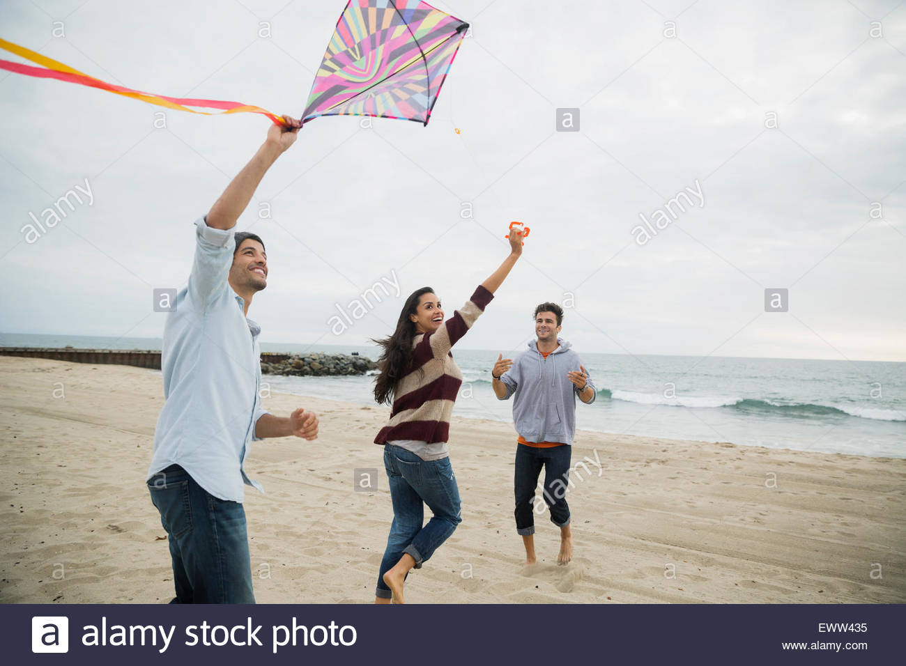Friends flying a kite on beach Stock Photo - Alamy