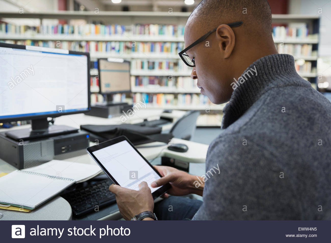 Man using tablet in library hi-res stock photography and images - Alamy