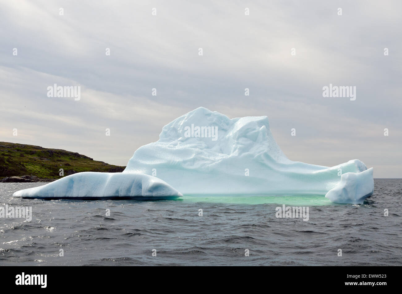 Bright white iceberg on dark water and rock background Stock Photo - Alamy