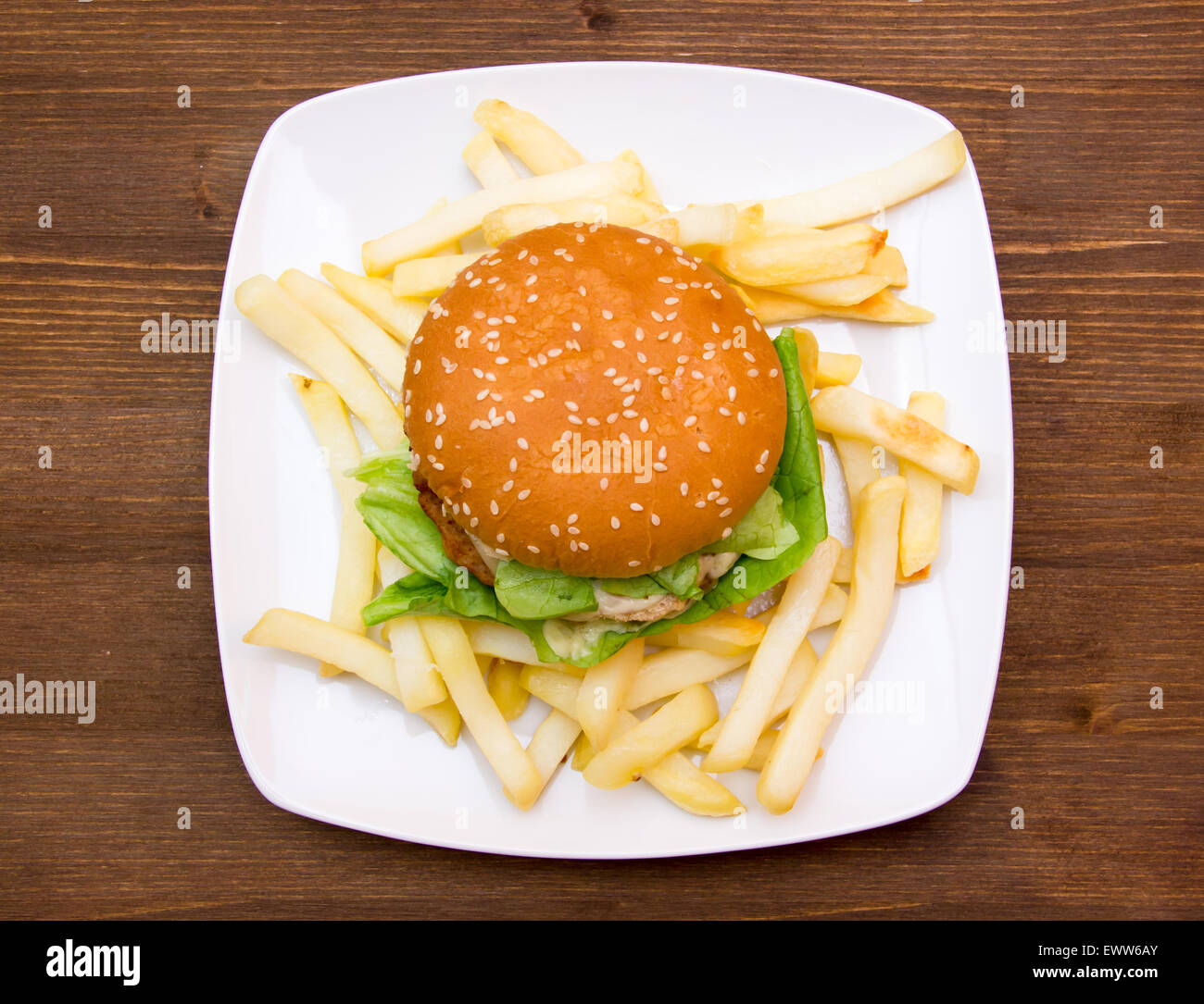 Hamburger with cheese and fries on wooden table seen from above Stock ...
