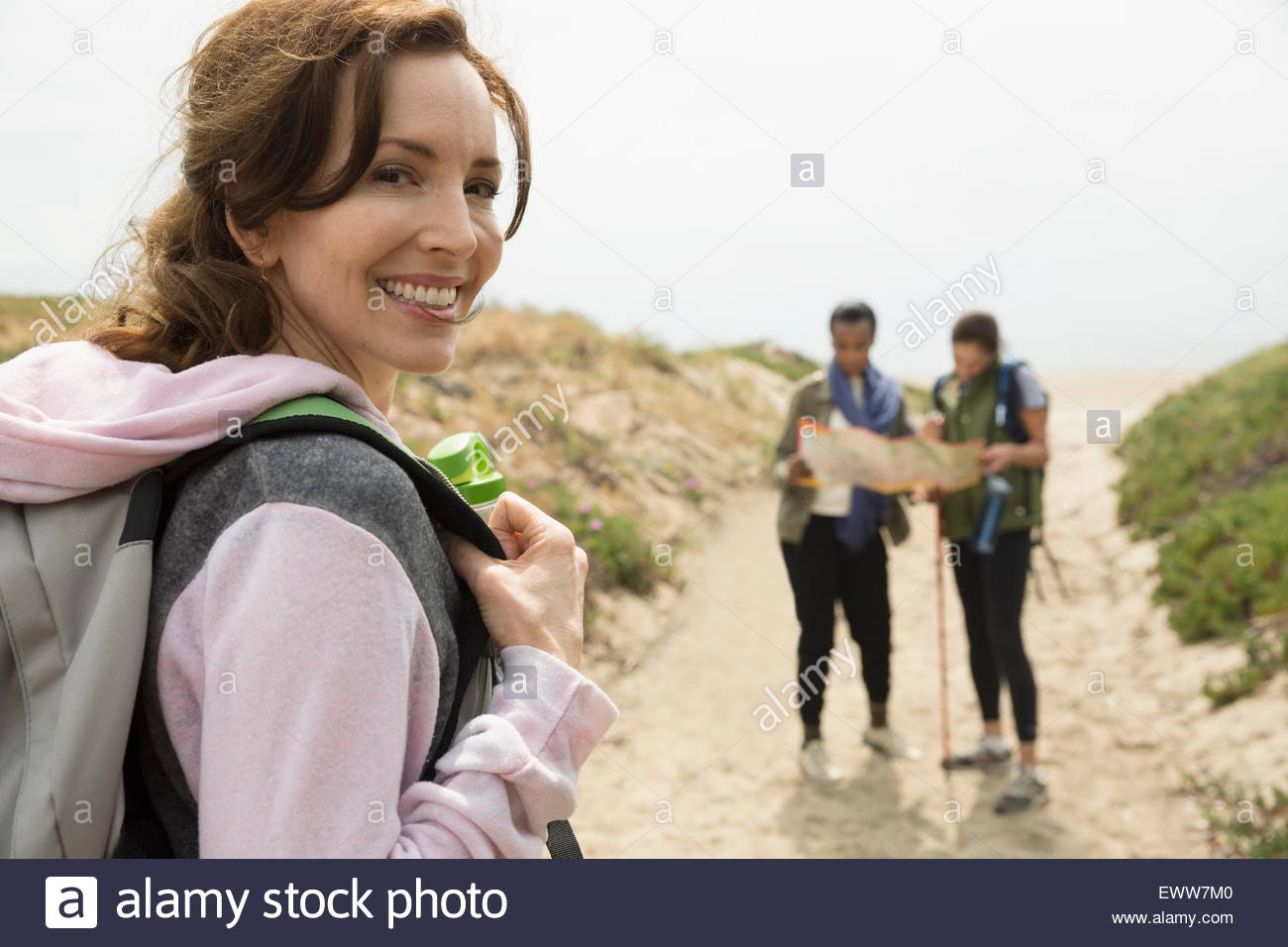Portrait smiling woman with backpack hiking with friends Stock Photo ...