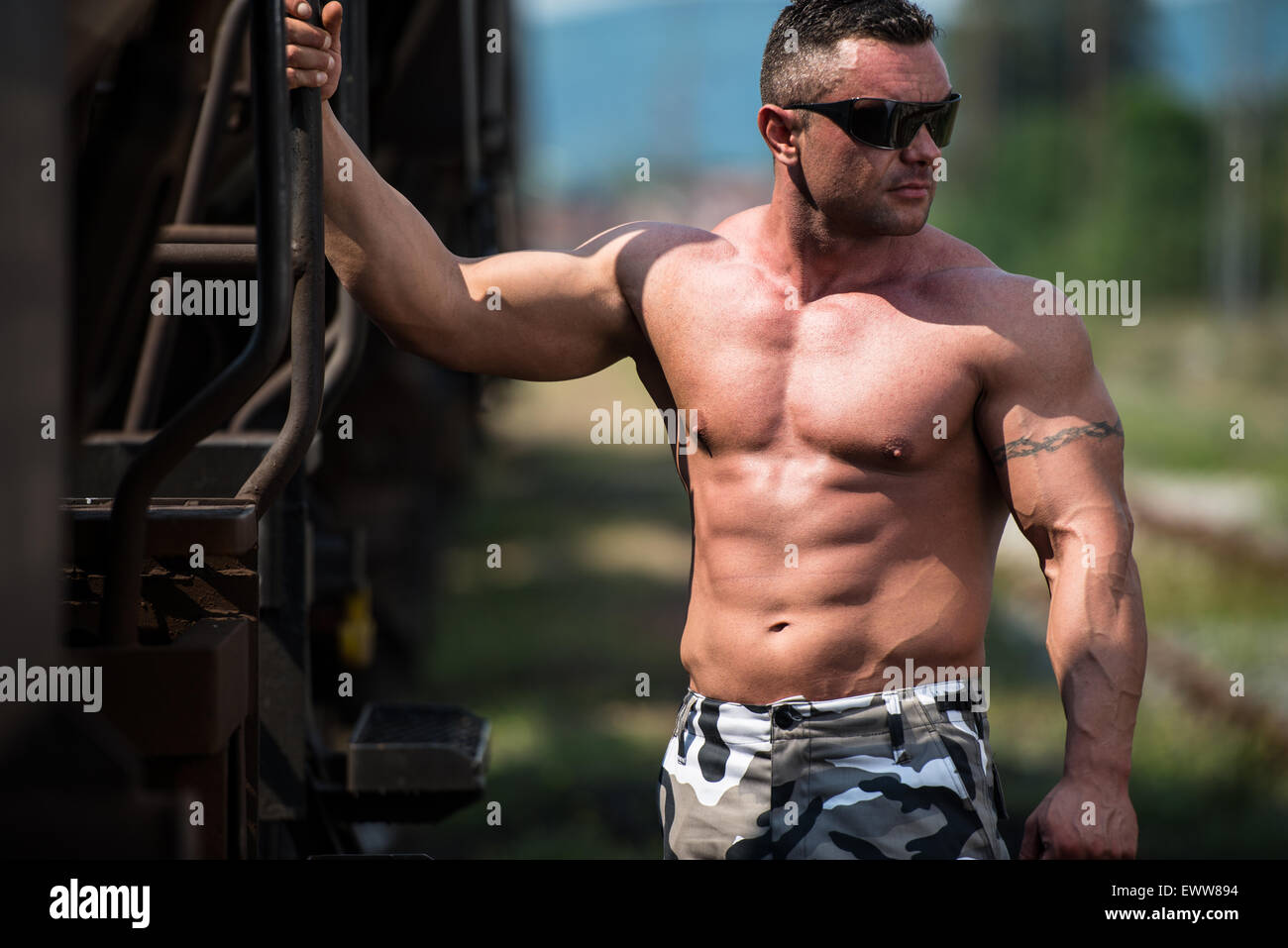 Male Bodybuilder Holding On To Train Stock Photo - Alamy