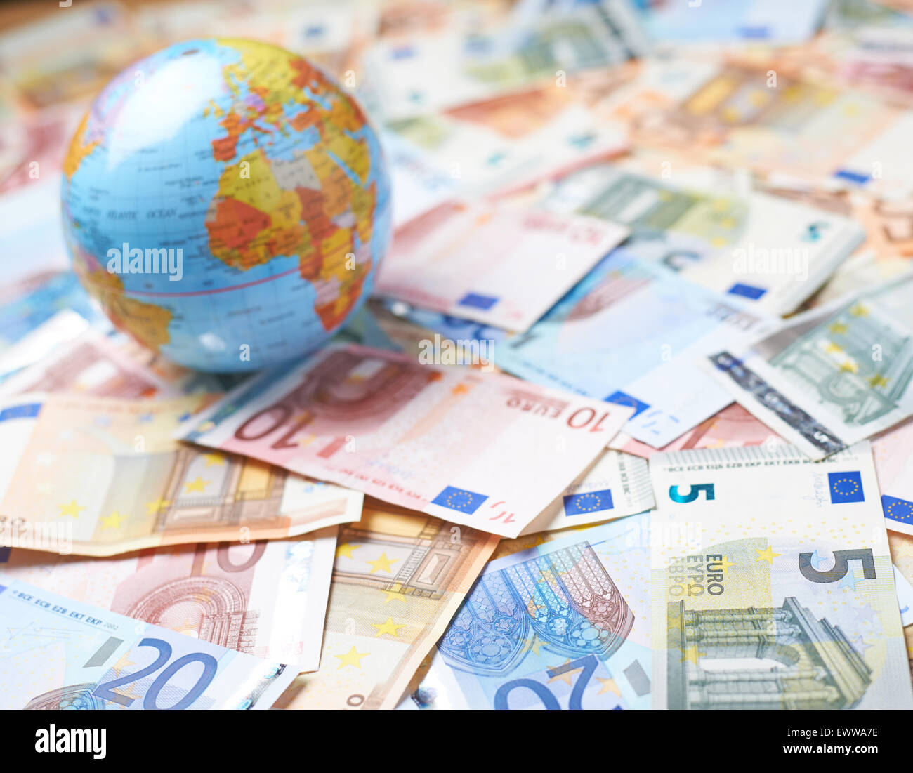 Earth globe over the pile of money Stock Photo - Alamy
