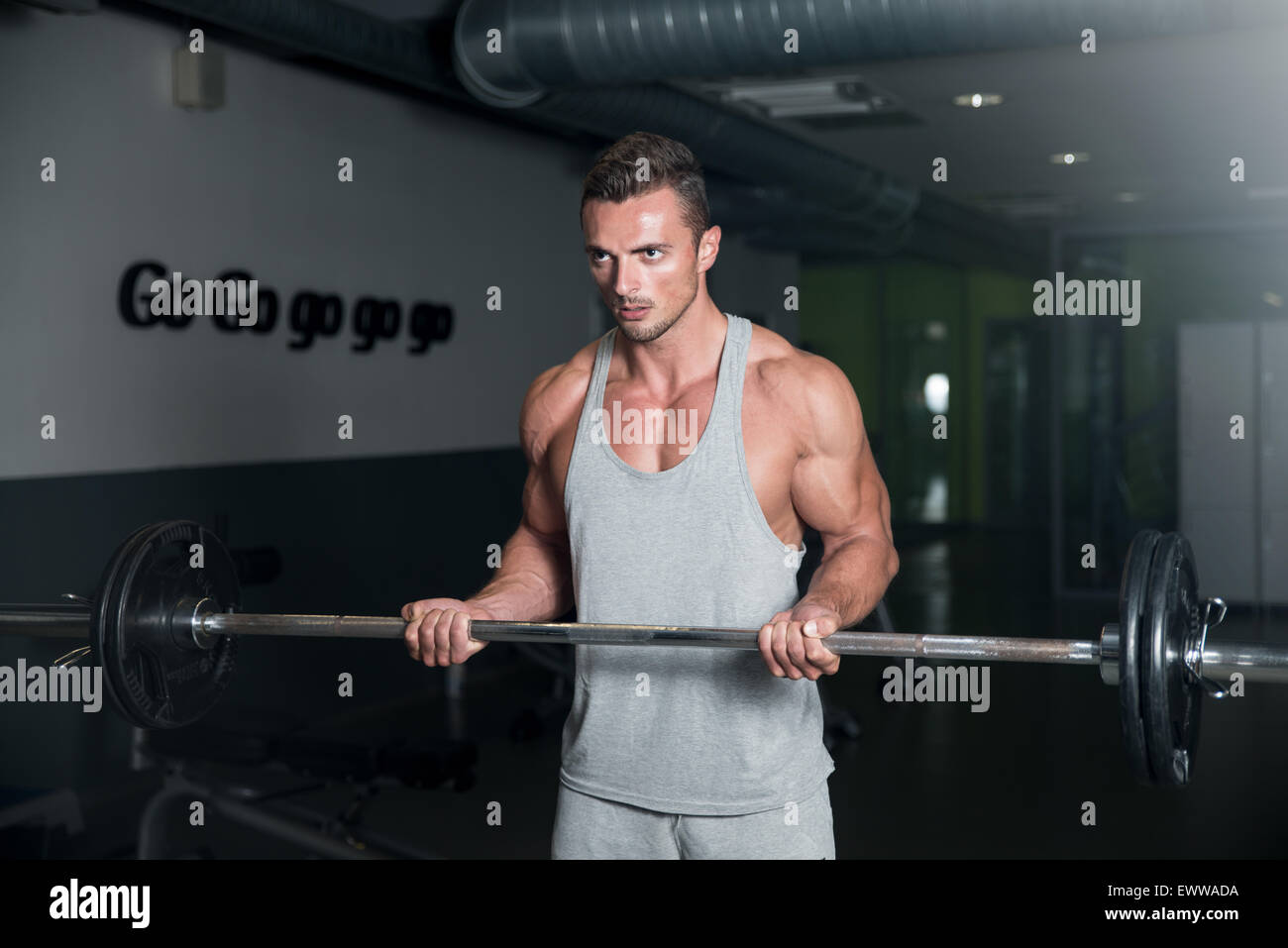Men In The Gym Exercising Biceps With Barbell Stock Photo - Alamy