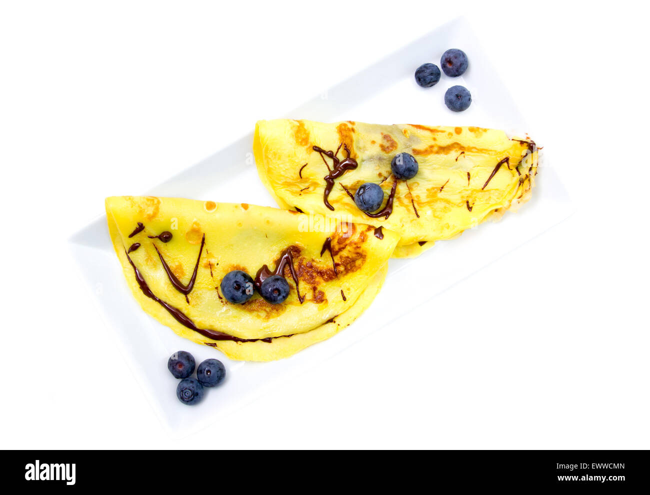 Sweet crepes with blueberries on white background viewed from above ...