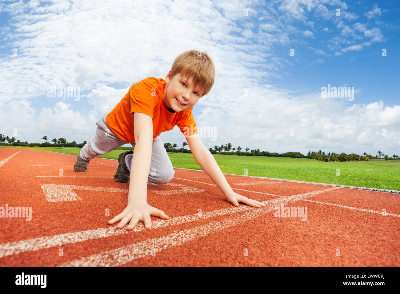 Smiling boy in uniform on the start ready to run Stock Photo - Alamy