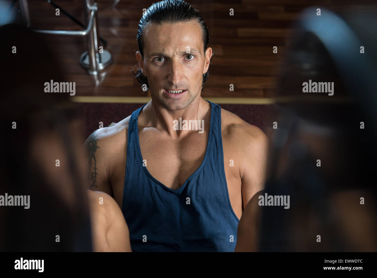 Man in gym on machine exercising Stock Photo - Alamy