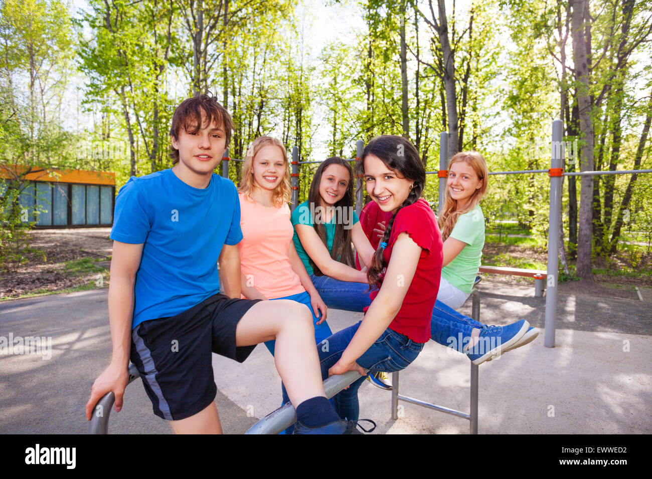 Friends sitting on brachiating at the playground Stock Photo - Alamy