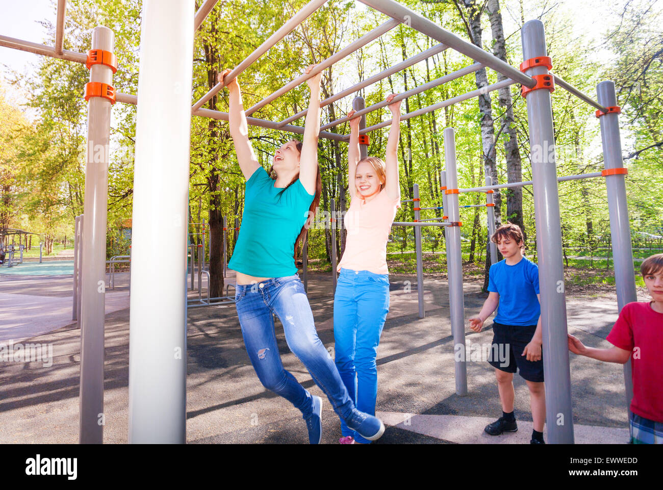Teenagers hang on horizontal bar at sports ground Stock Photo - Alamy
