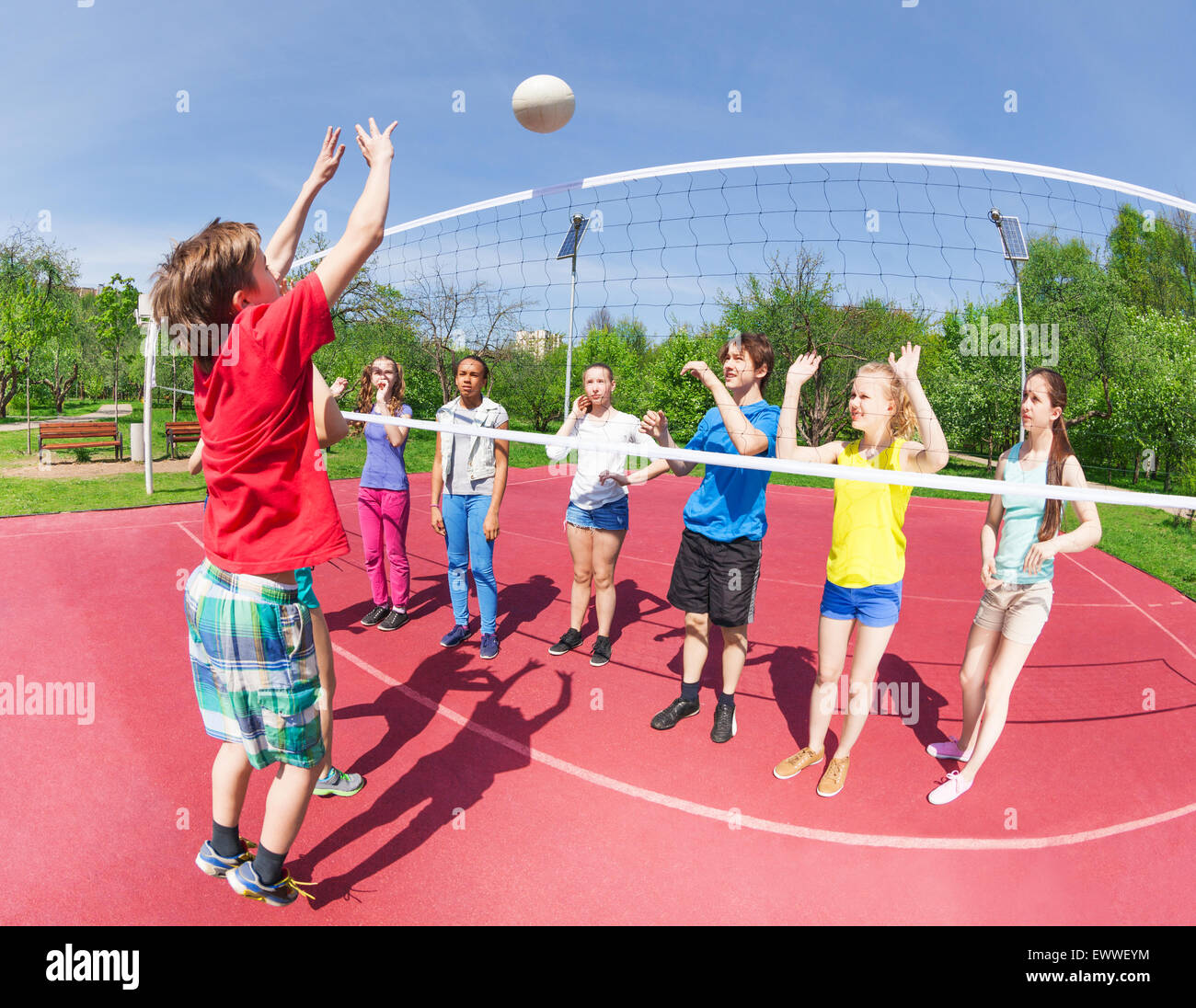 Active boy and girls playing volleyball together Stock Photo - Alamy