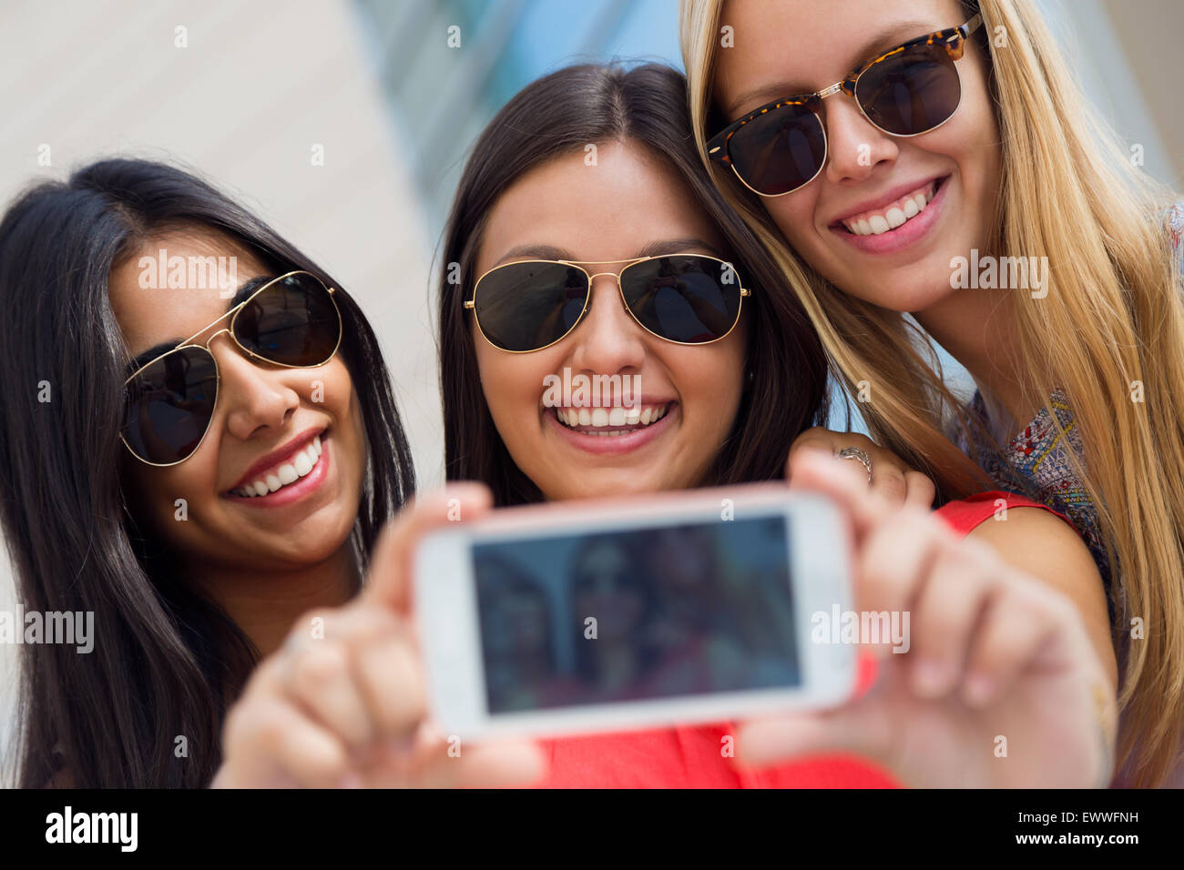 Portrait of three friends taking photos with a smartphone Stock Photo ...