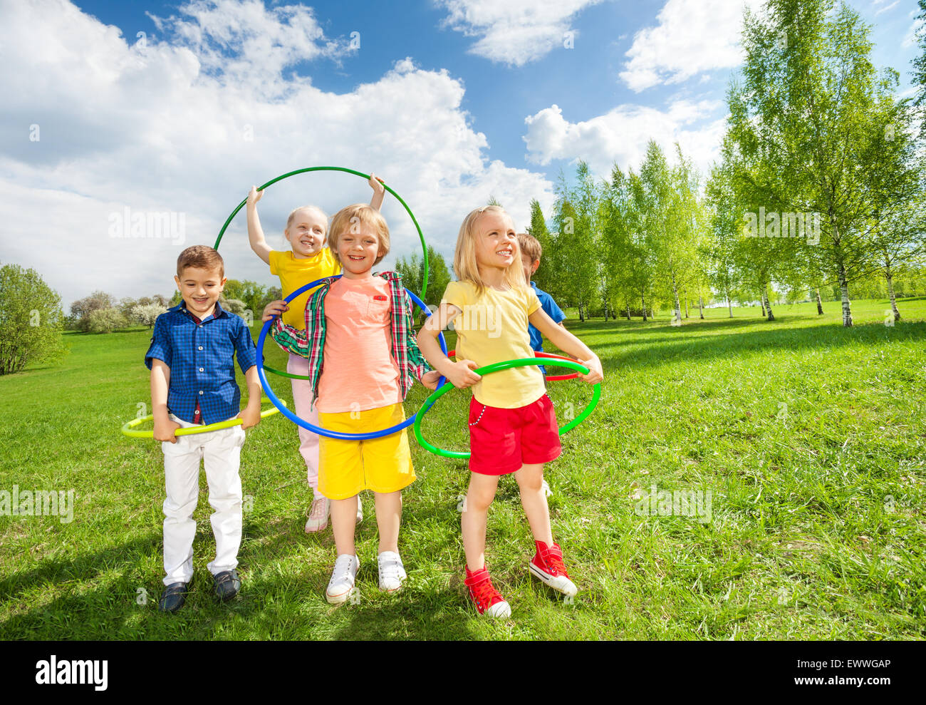 Happy children holding hula hoops during exercises Stock Photo - Alamy
