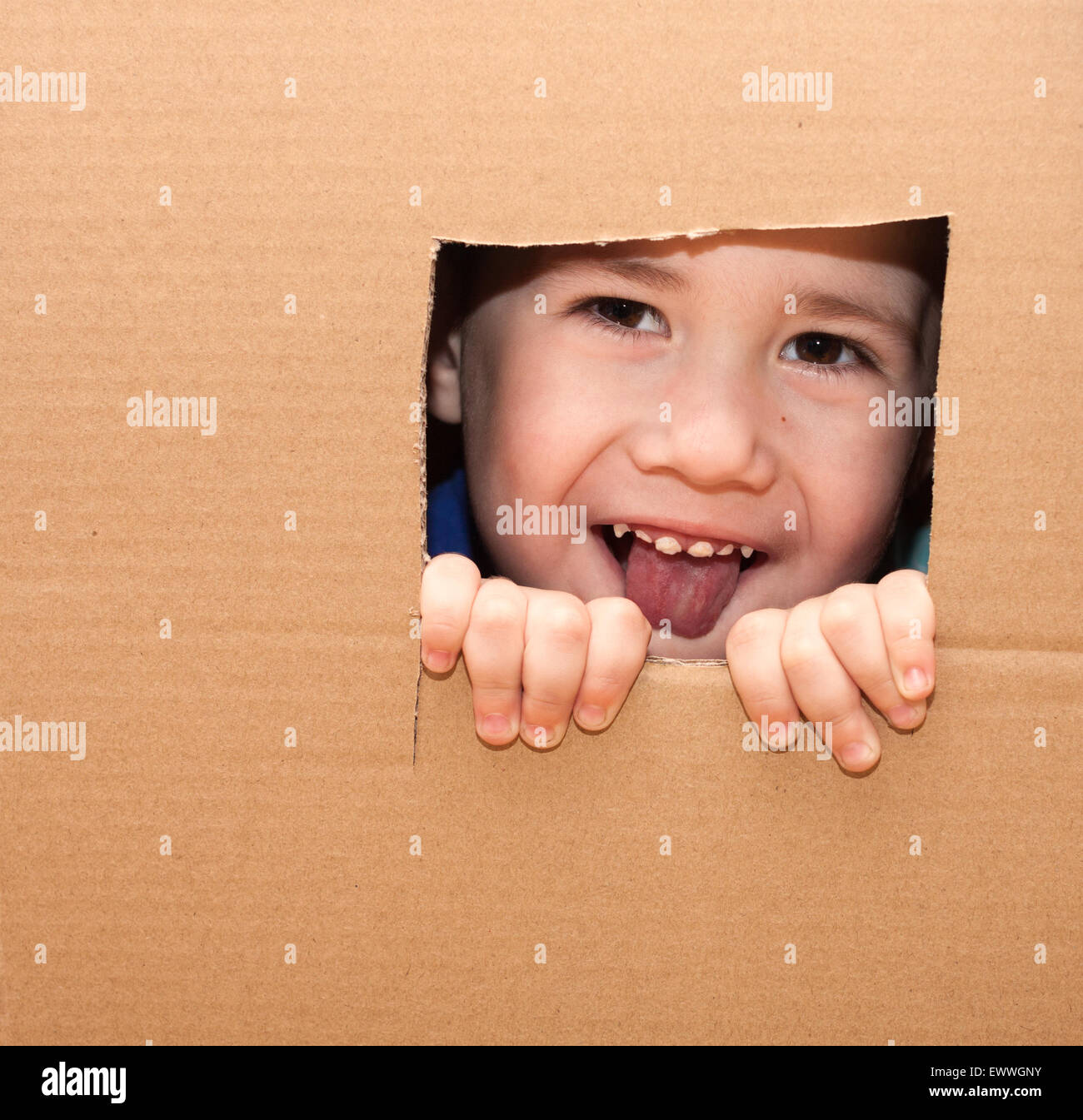 Child smiling looking out of a cardboard box Stock Photo - Alamy
