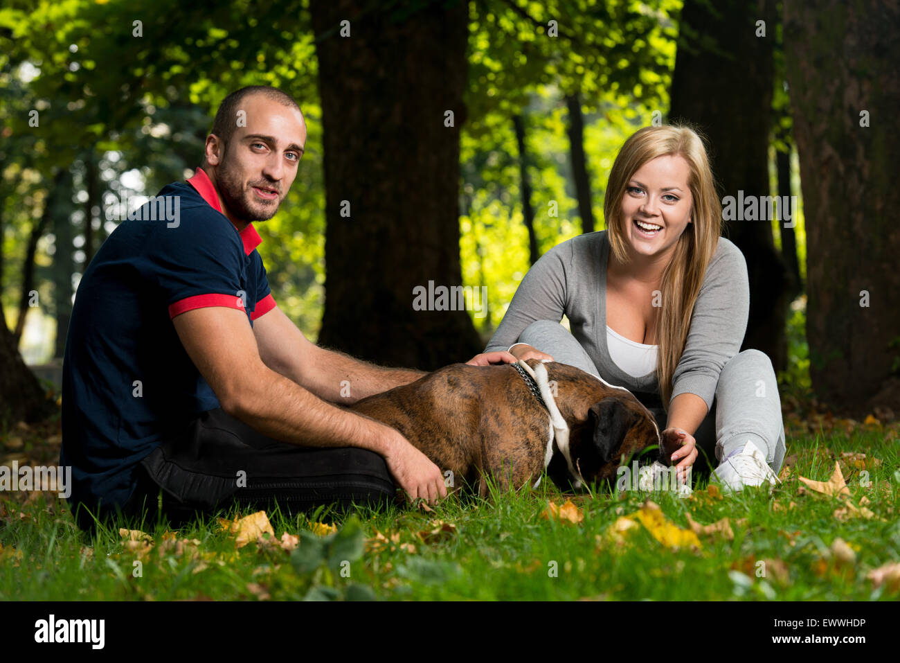 Young People With Their Dog In The Park Stock Photo - Alamy