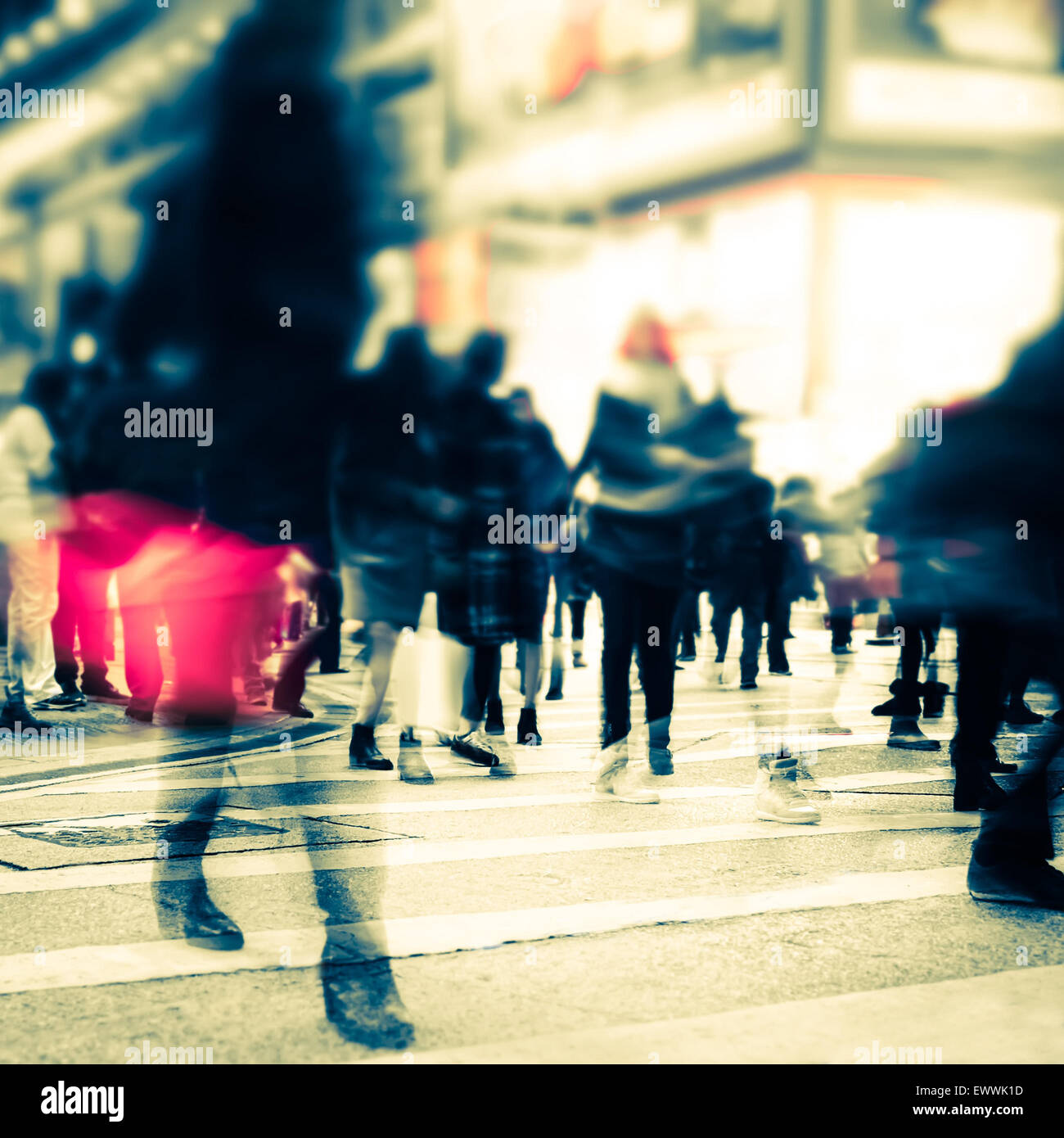 Blurred image of people moving in crowded night city street. Art toning ...