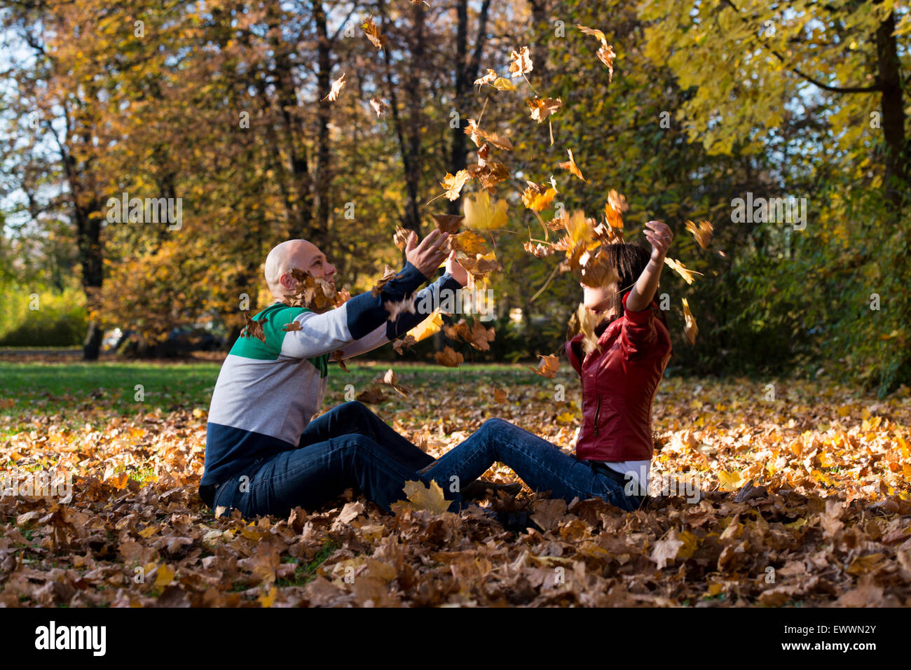 Beautiful young woman throwing leaves hi-res stock photography and ...