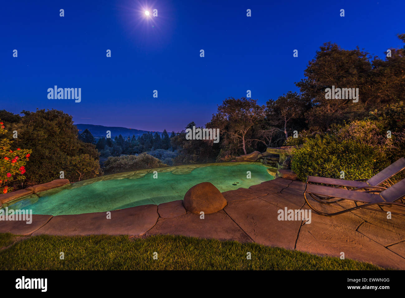 Illuminated swimming pool at night with bright star overhead Stock ...