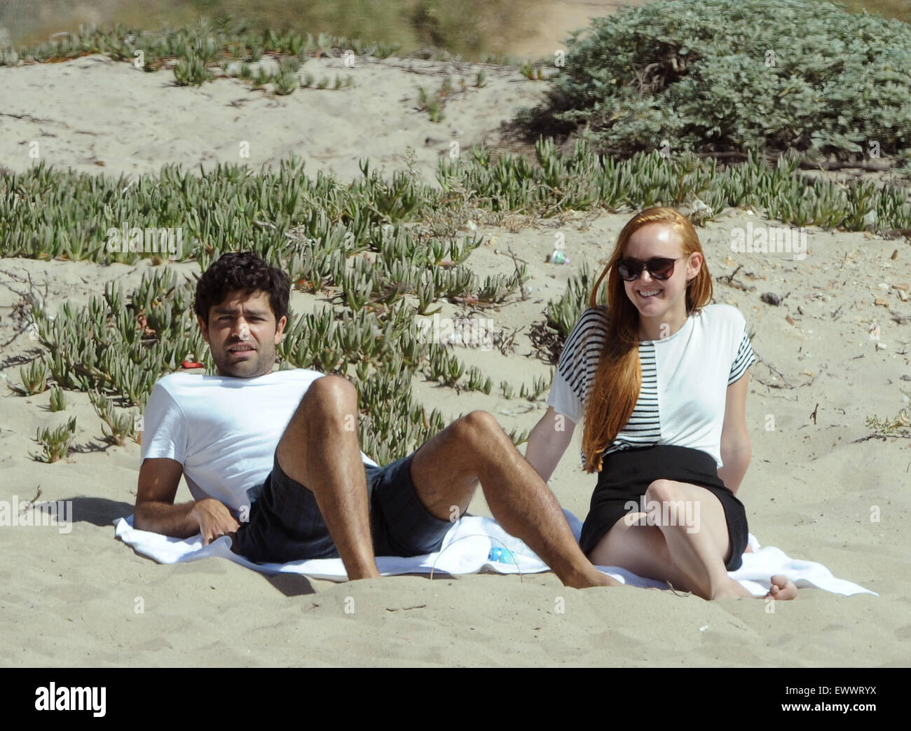 Actor Adrian Grenier enjoys a hot day on the beach with a gal pal in ...